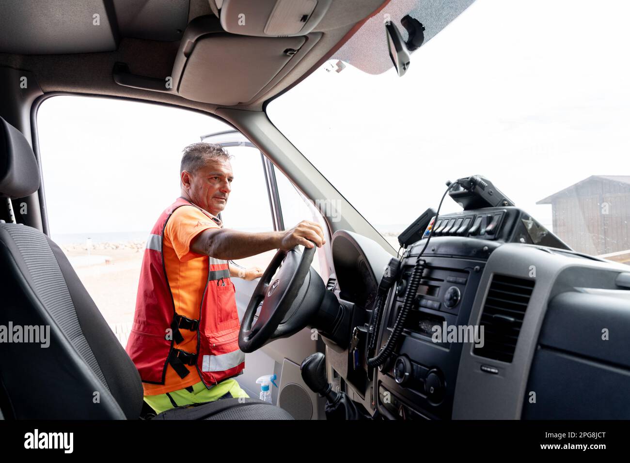 Photo with focus on a lifeguard entering to the ambulance to drive ...