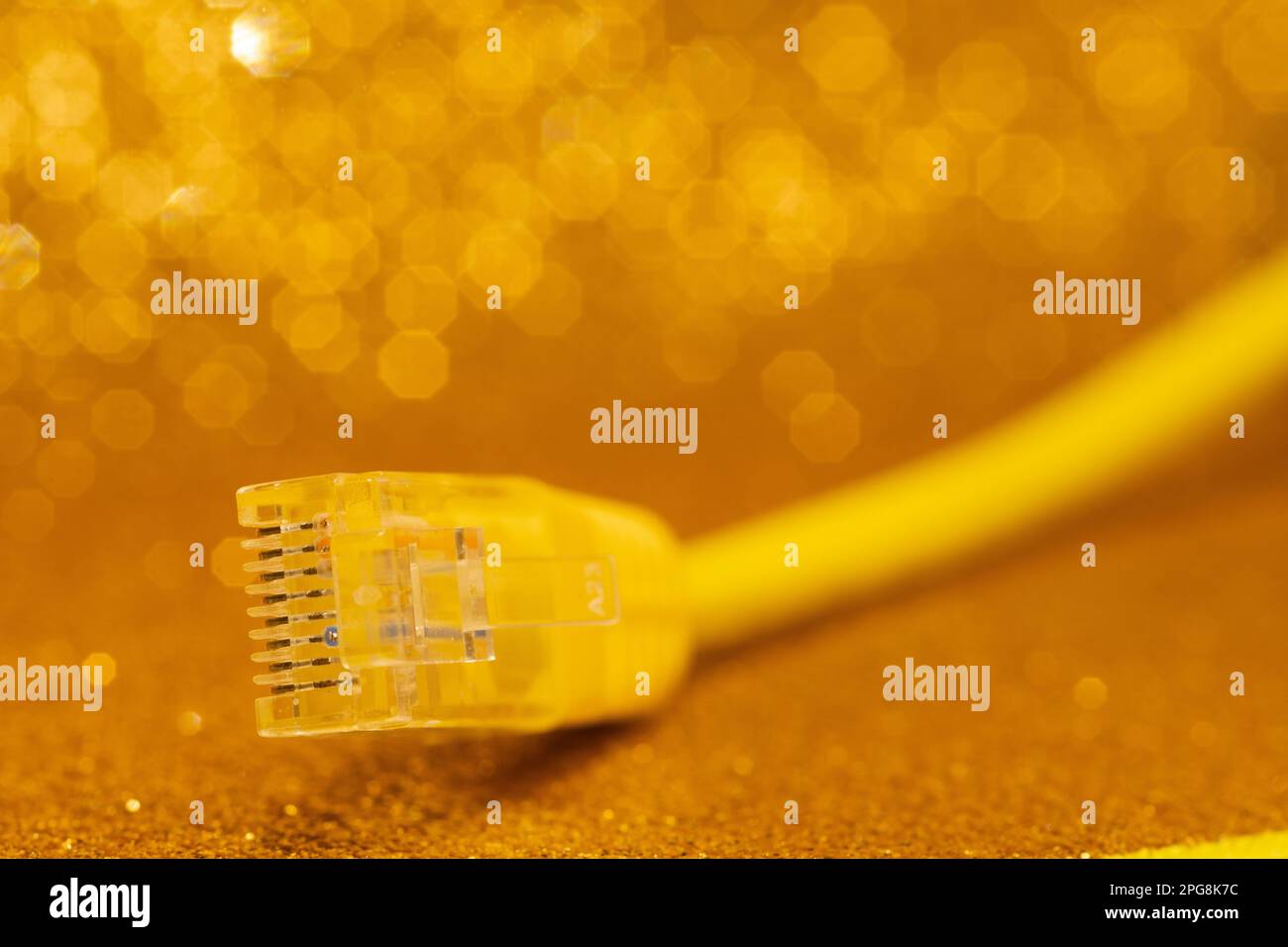 A high-resolution closeup of a yellow Ethernet cable lying on a bright ...