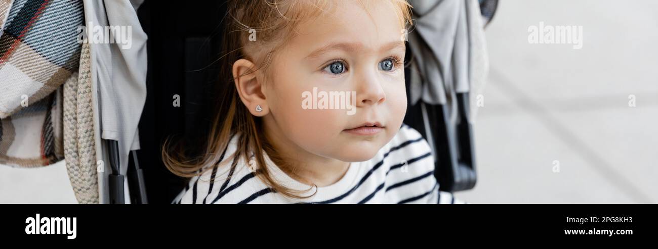 toddler kid in striped long sleeve shirt sitting in baby stroller ...