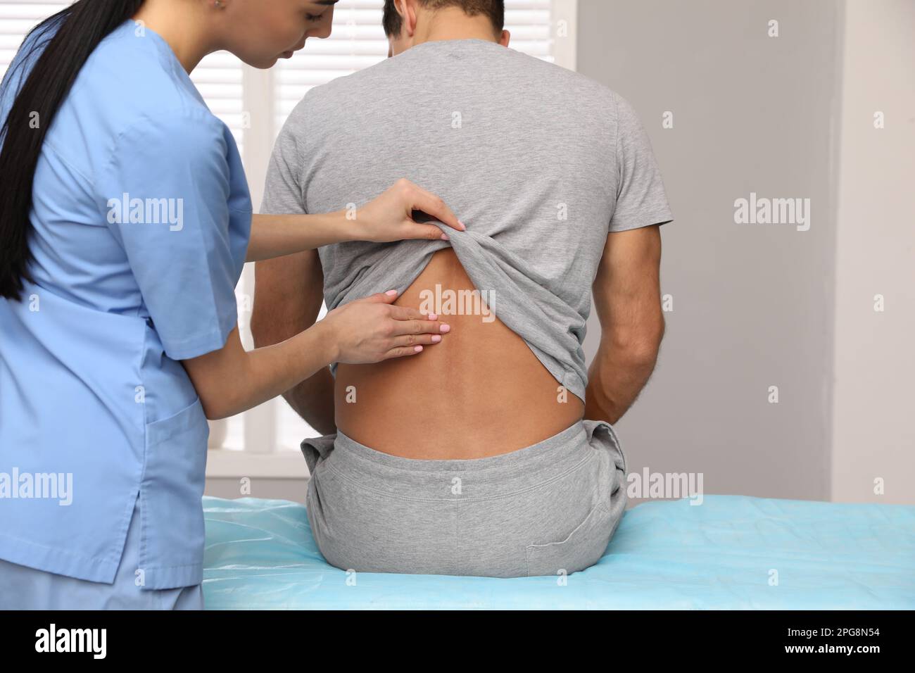 Orthopedist Examining Mans Back In Clinic Scoliosis Treatment Stock