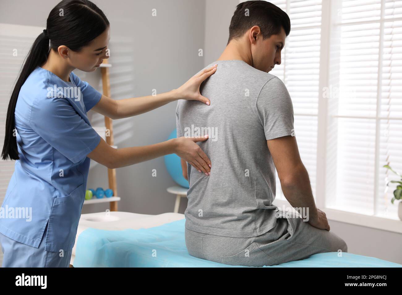 Orthopedist examining man's back in clinic. Scoliosis treatment Stock ...