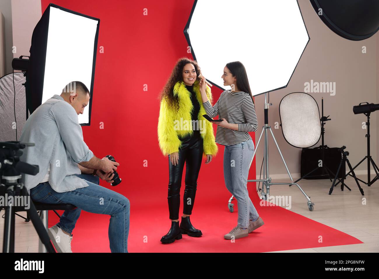 Professional photographer and makeup artist with model in studio Stock ...