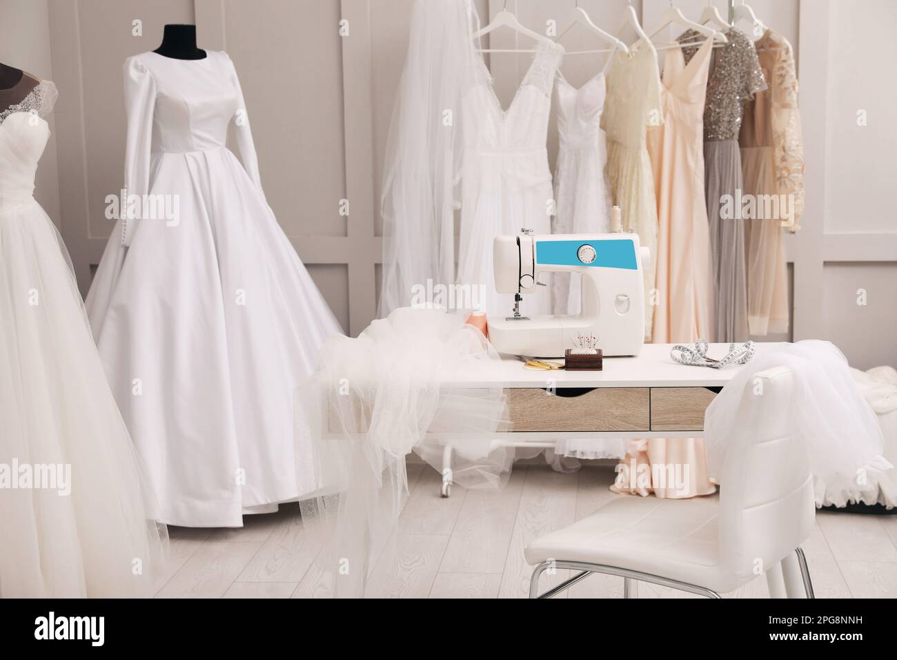 Dressmaking workshop interior with wedding dresses and equipment Stock ...