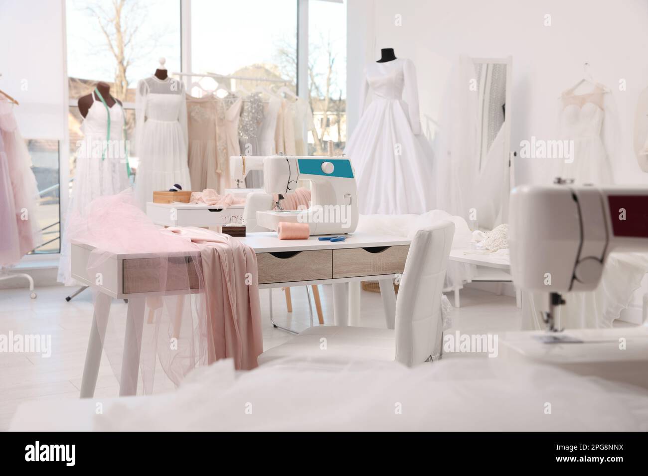 Dressmaking workshop interior with wedding dresses and equipment Stock ...