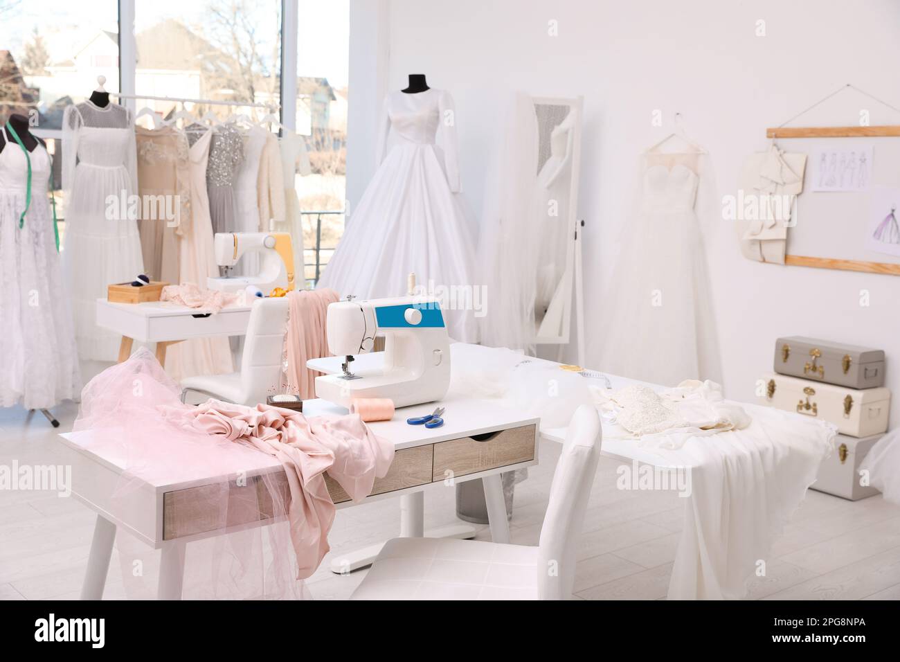Dressmaking workshop interior with wedding dresses and equipment Stock ...