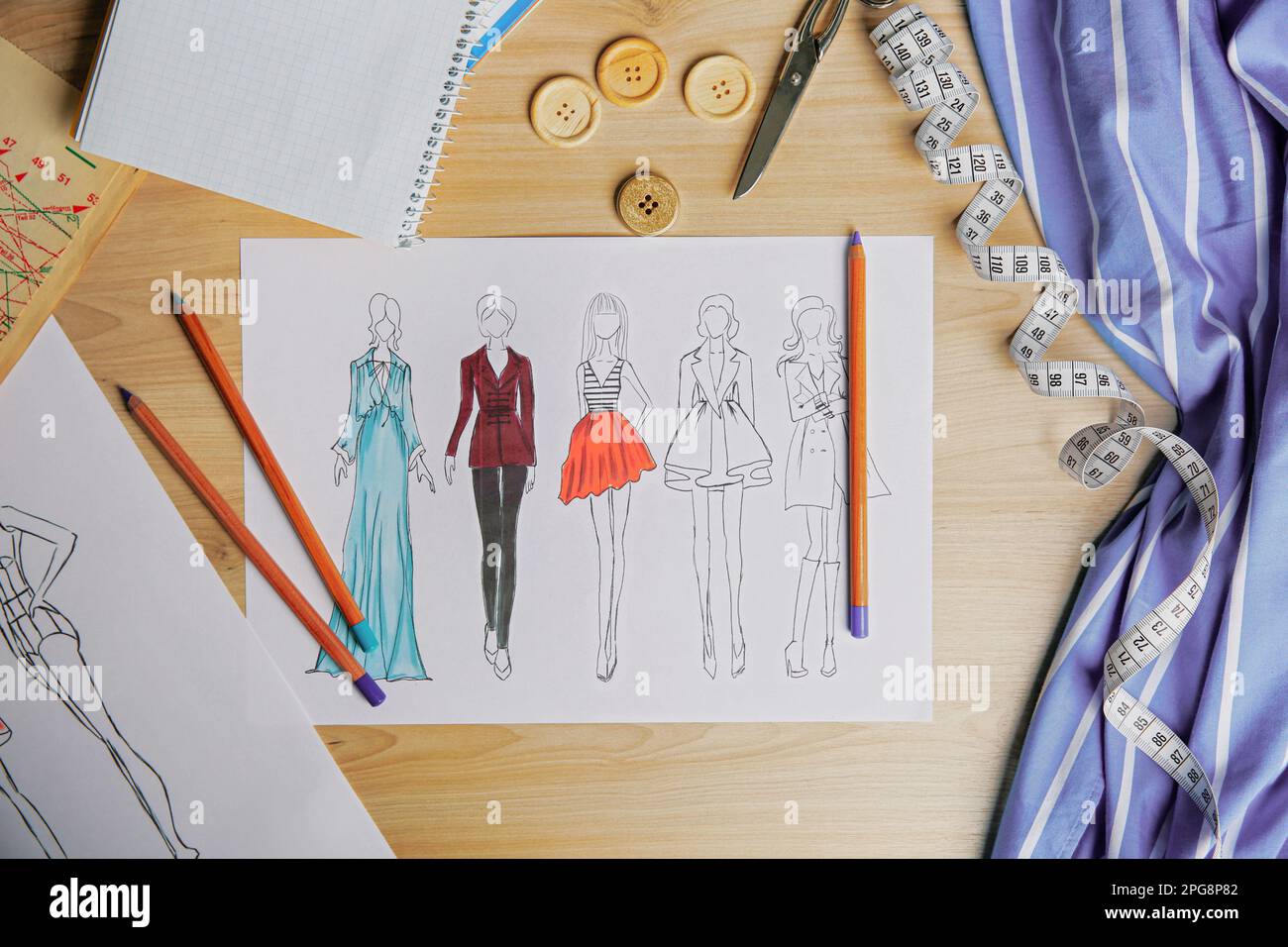 Sketch of fashion clothes and thread supplies at designer's workplace ...