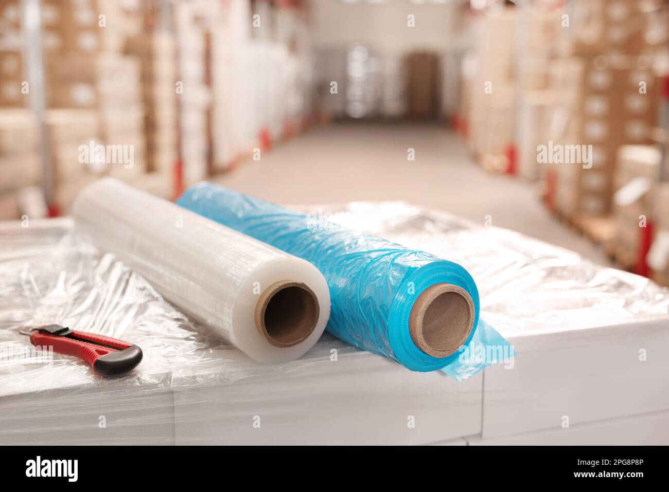 Rolls of different stretch wraps and utility knife on boxes in ...