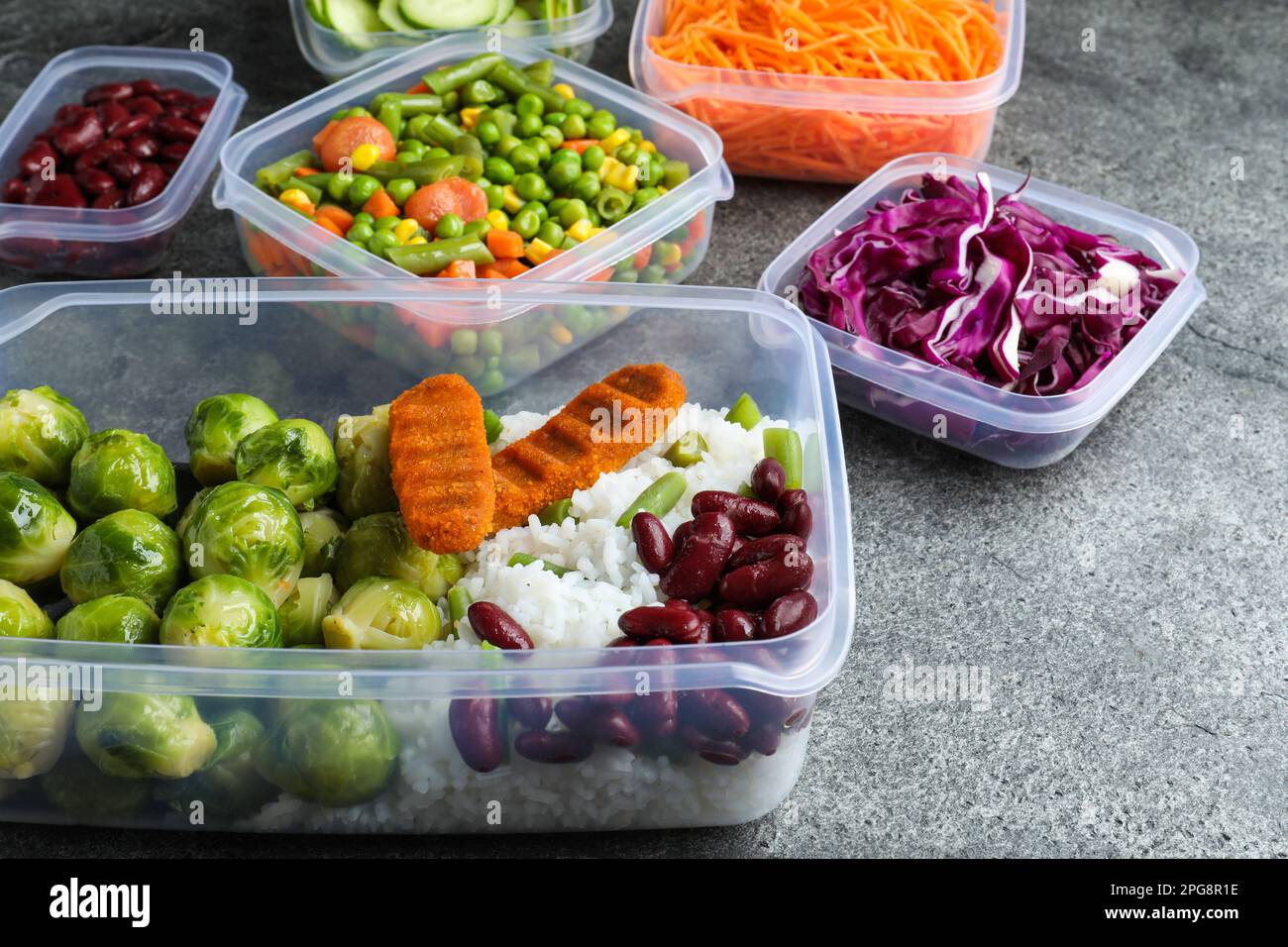 Set of plastic containers with fresh food on grey table Stock Photo - Alamy