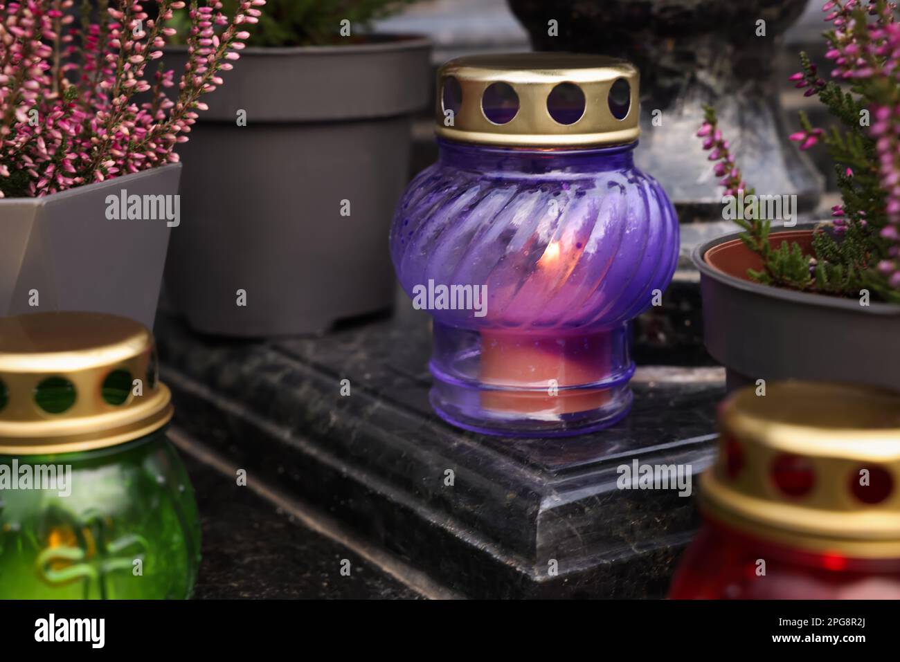 Different grave lanterns on granite surface at cemetery Stock Photo - Alamy