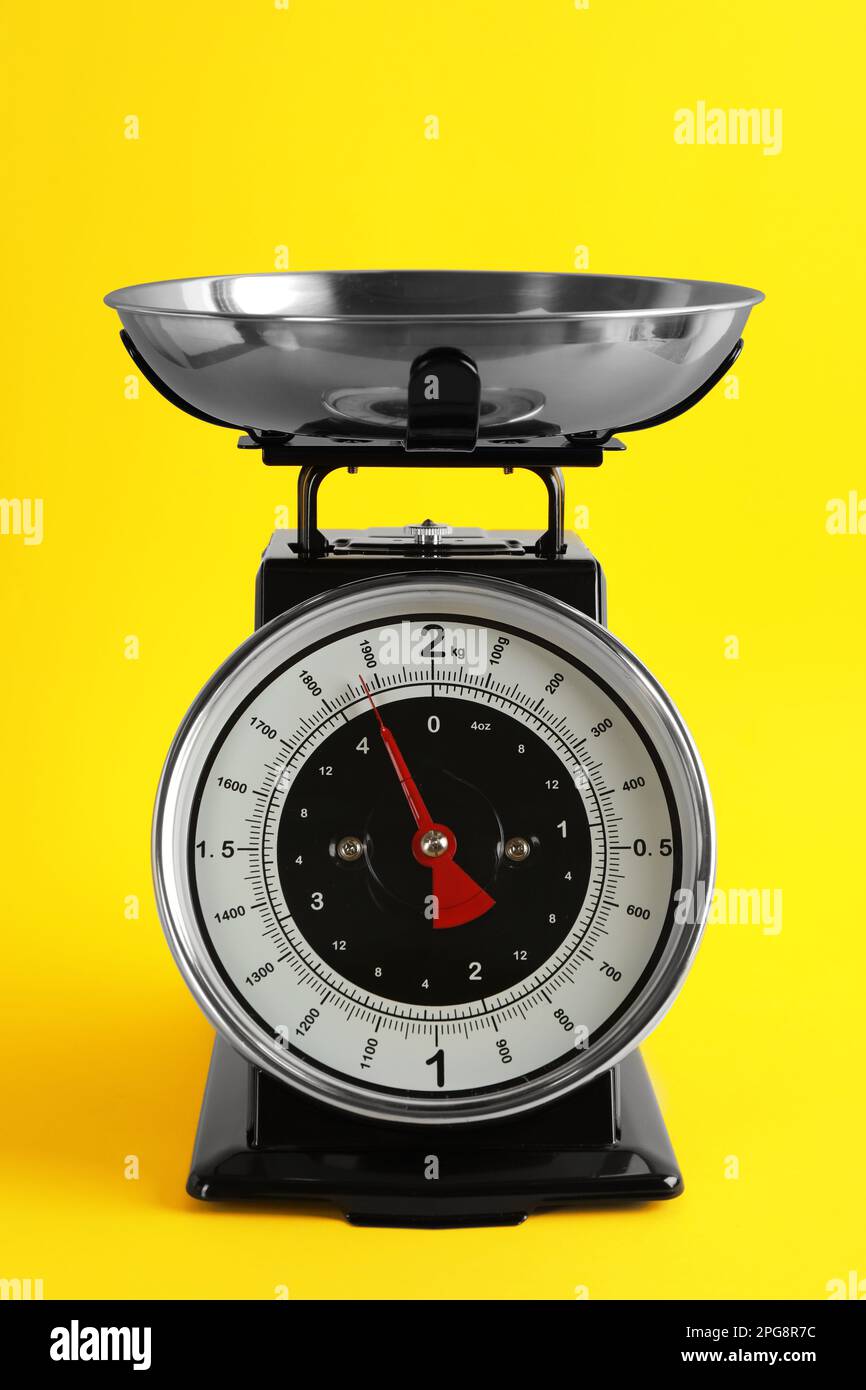 Retro mechanical kitchen scale on yellow background Stock Photo - Alamy
