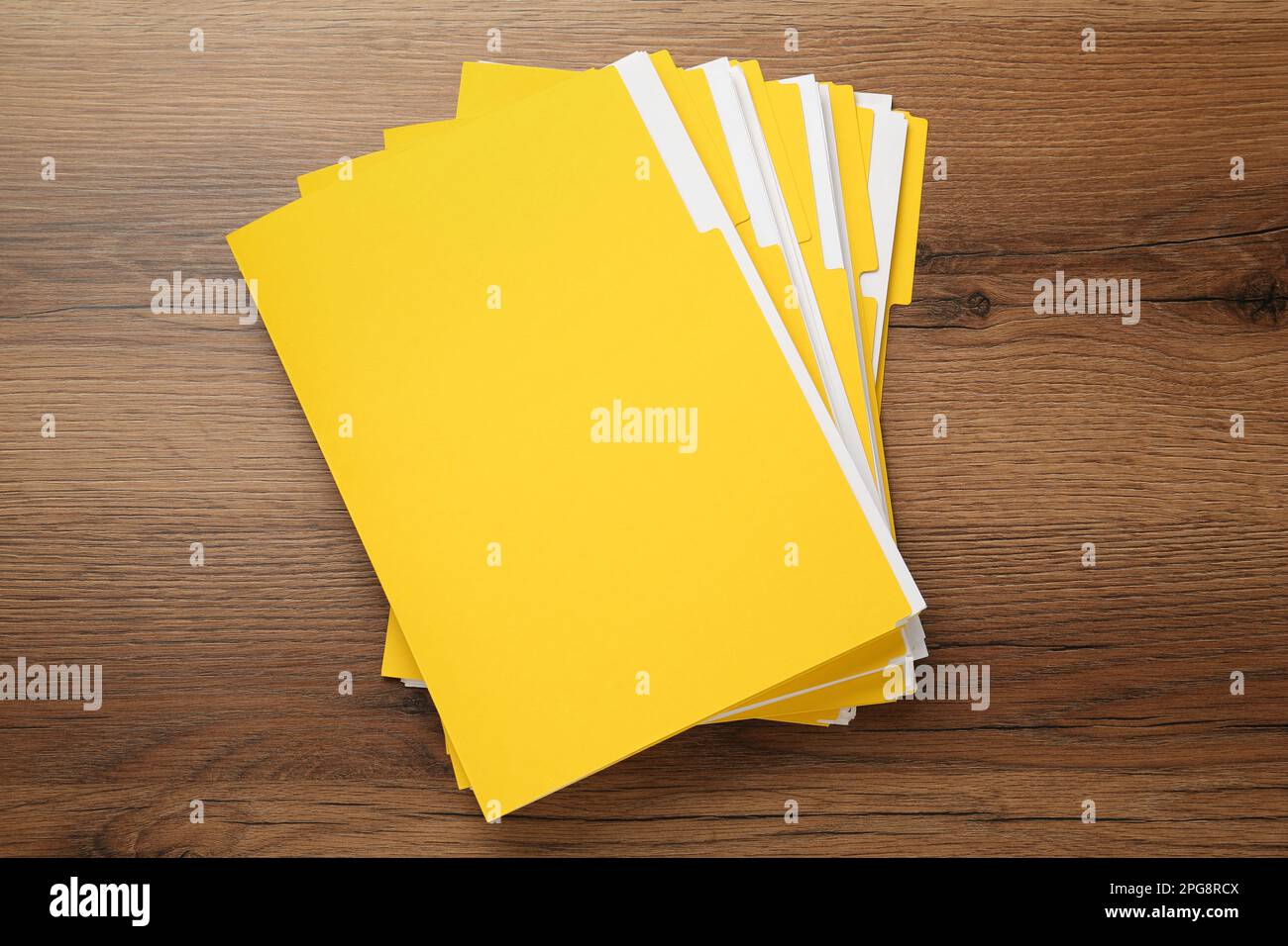 Yellow files with documents on wooden table, top view Stock Photo - Alamy
