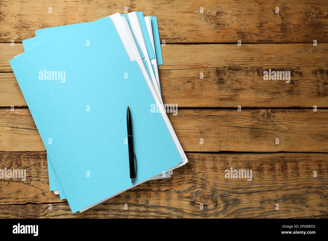 Turquoise files with documents and pen on wooden table, top view. Space ...