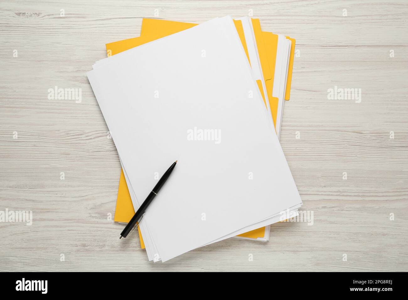 Yellow files with blank sheets of paper and pen on white wooden table ...