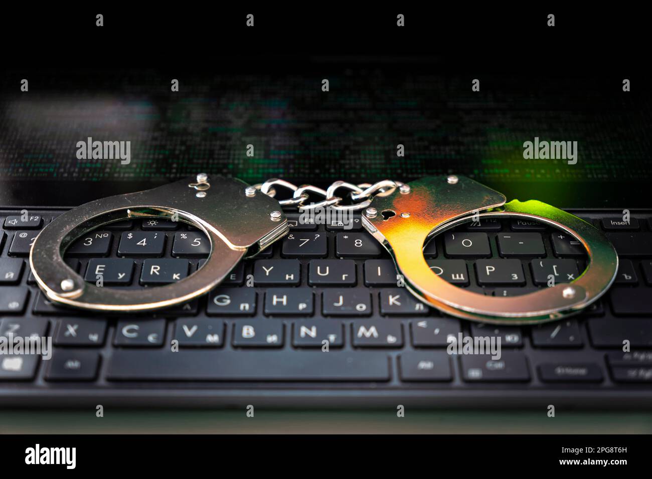 Handcuffs on the laptop close-up. Cyber hacker crime concept. metal ...