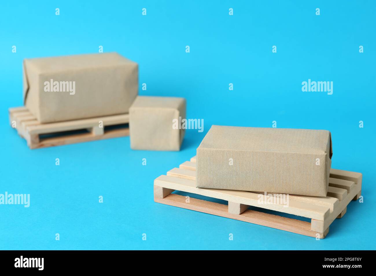 Wooden pallets and boxes on light blue background Stock Photo - Alamy