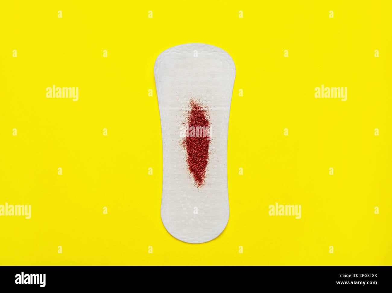 Sanitary pad with red glitter on yellow background, top view. Menstrual ...