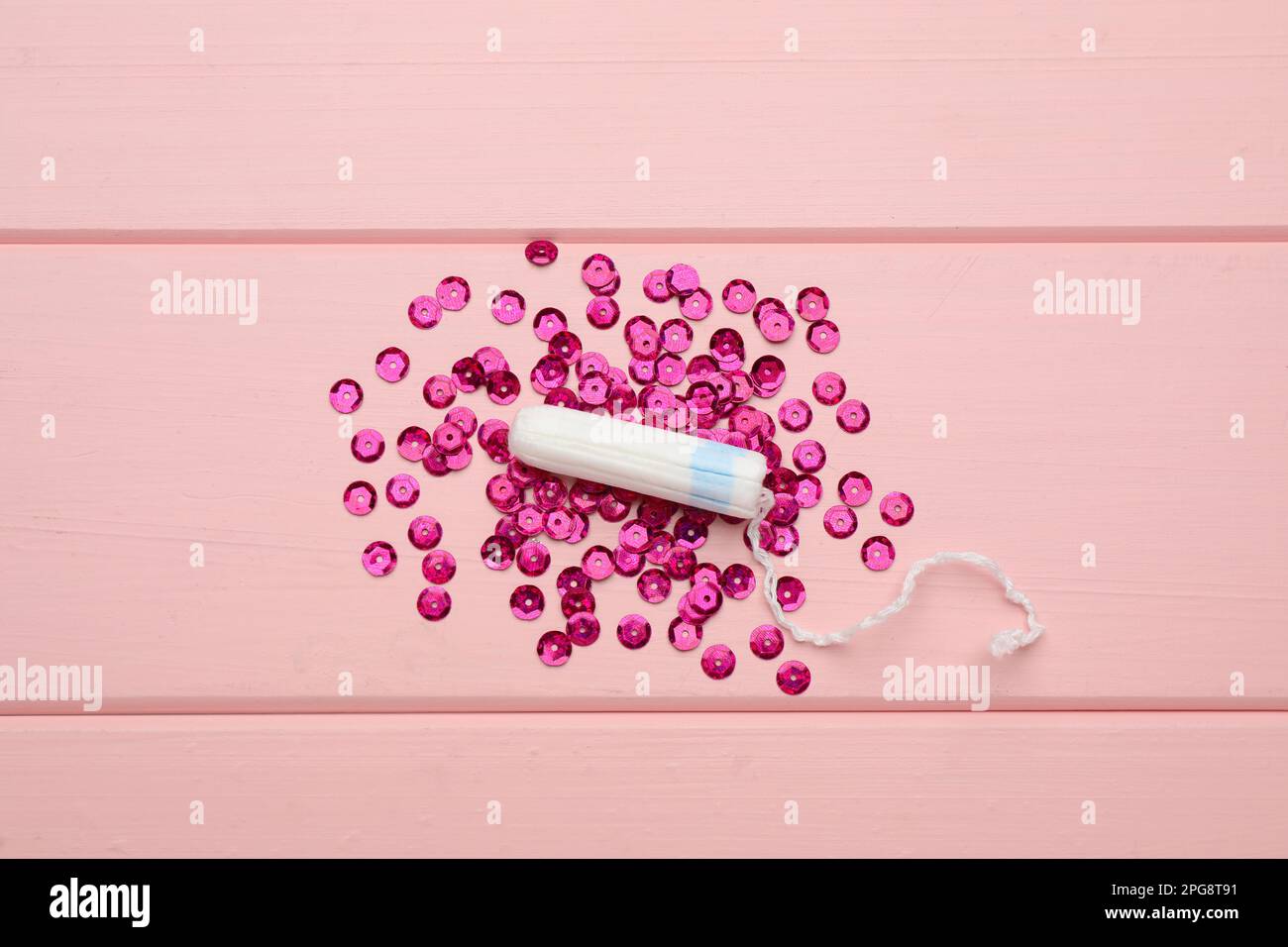 Tampon and sequins on pink wooden background, flat lay. Menstrual ...