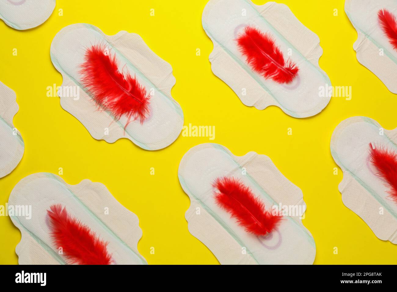 Menstrual pads with red feathers on yellow background, flat lay Stock ...