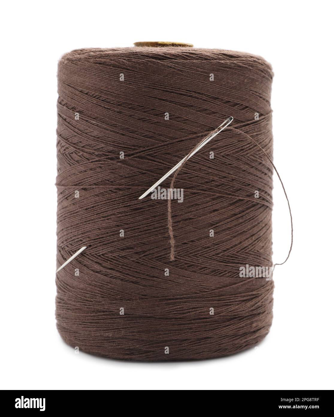Brown sewing thread with needle on white background Stock Photo - Alamy