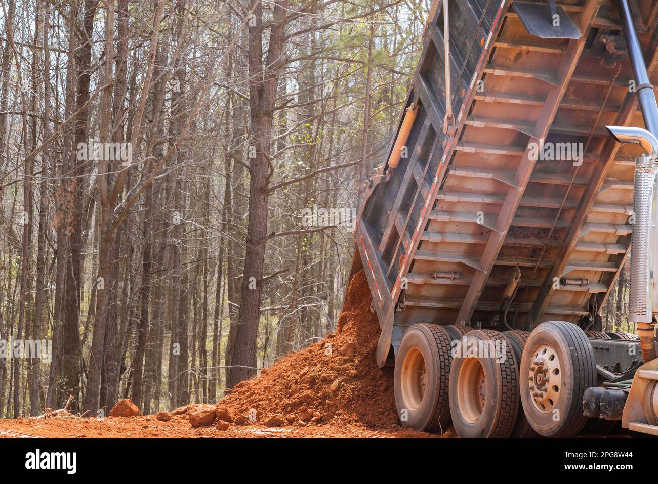 Dump truck is moving down soil leveling ground on construction site ...