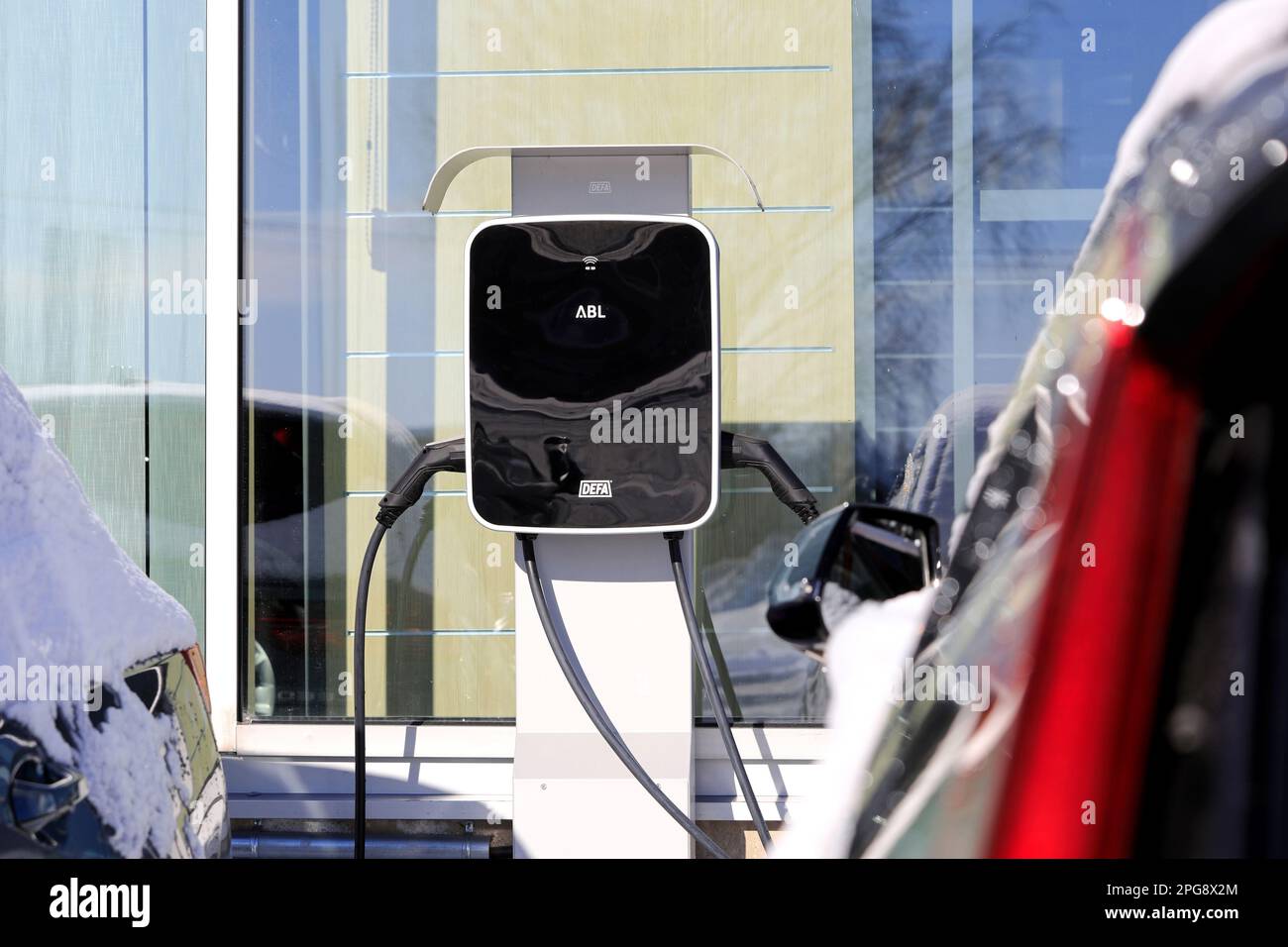 Two electric cars plugged in DEFA charger with two outlets to recharge ...