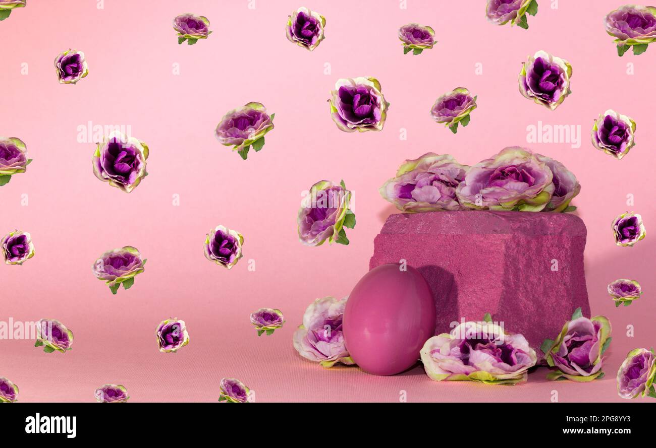 pink Easter egg leaning on the pink stone with flowers, pink background ...