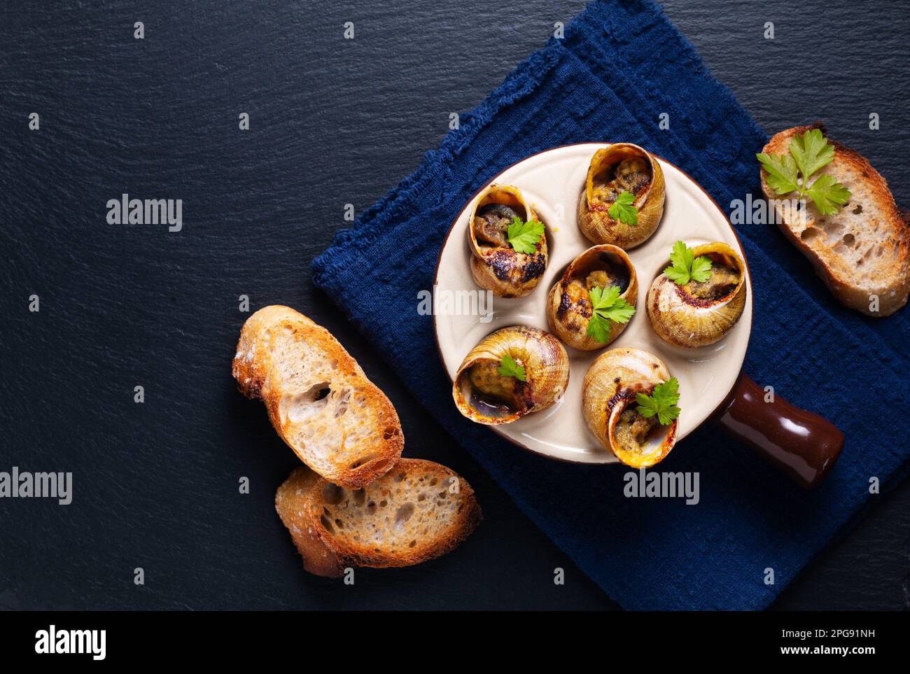 Food concept Escargots Baked French snails with Garlic butter on black ...