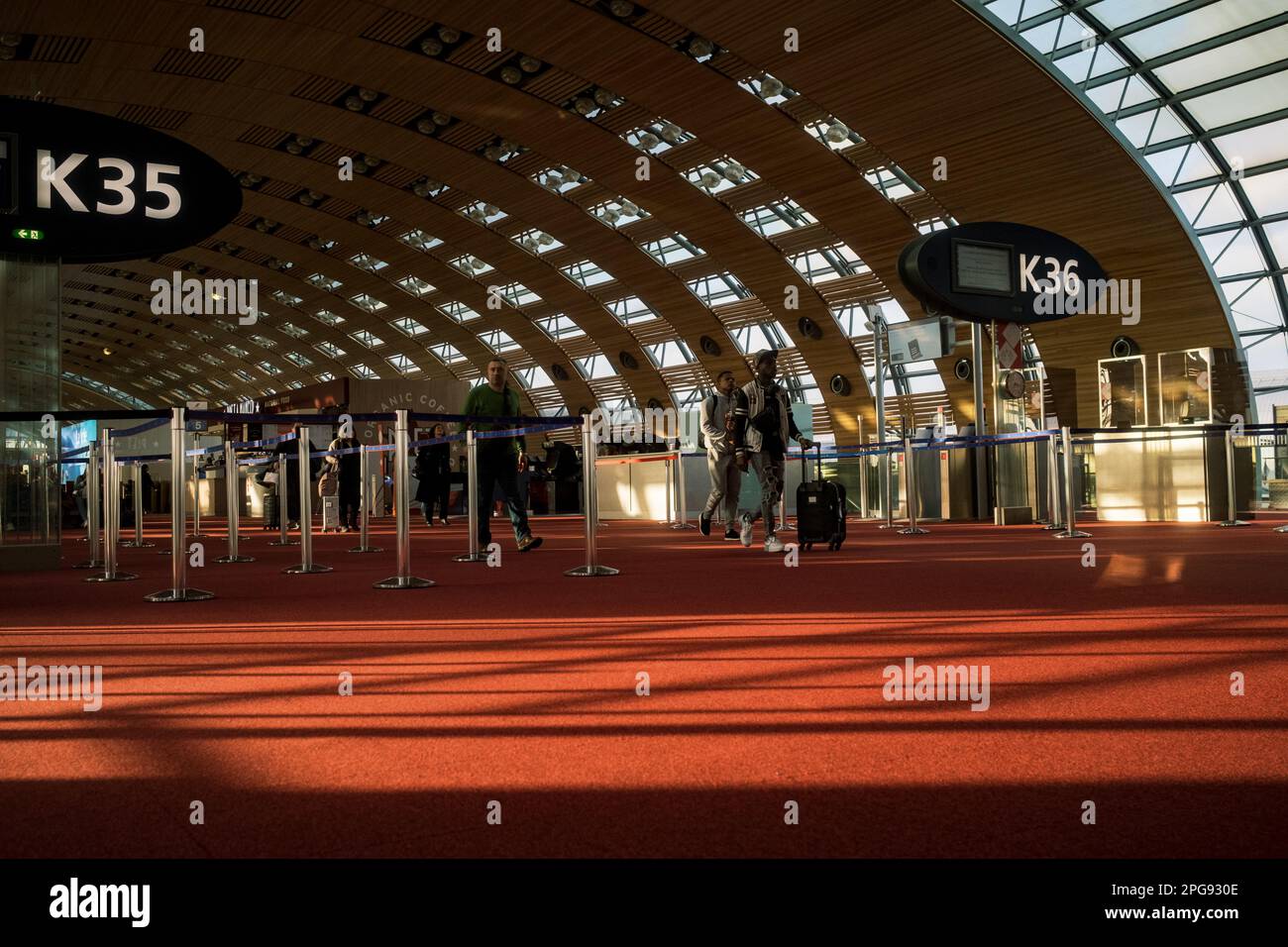A group of people standing beneath the expansive glass ceiling of an ...
