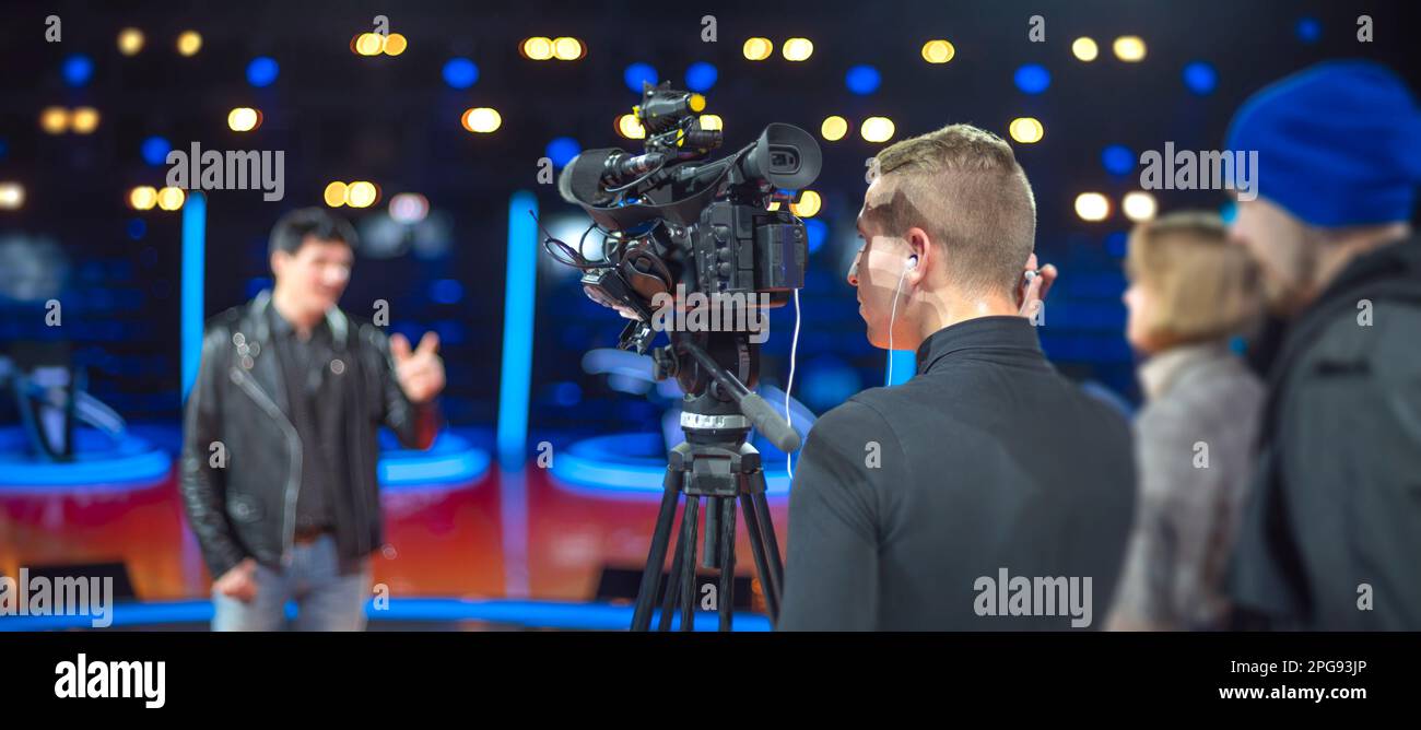 cameraman filming an interview on a tv camera Stock Photo - Alamy