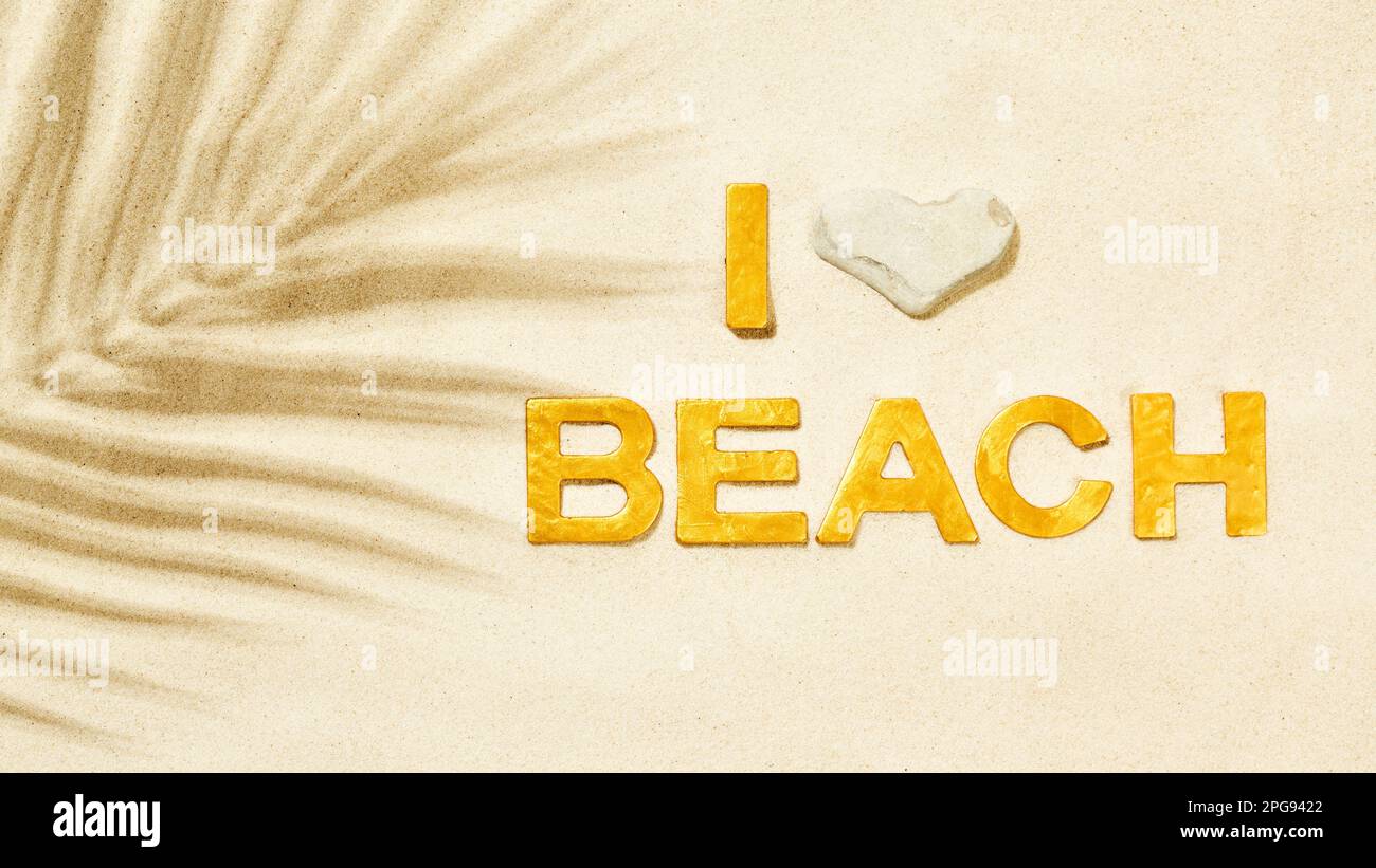 I Love Beach - Golden letters in the sand and shadow of palm leaf Stock ...