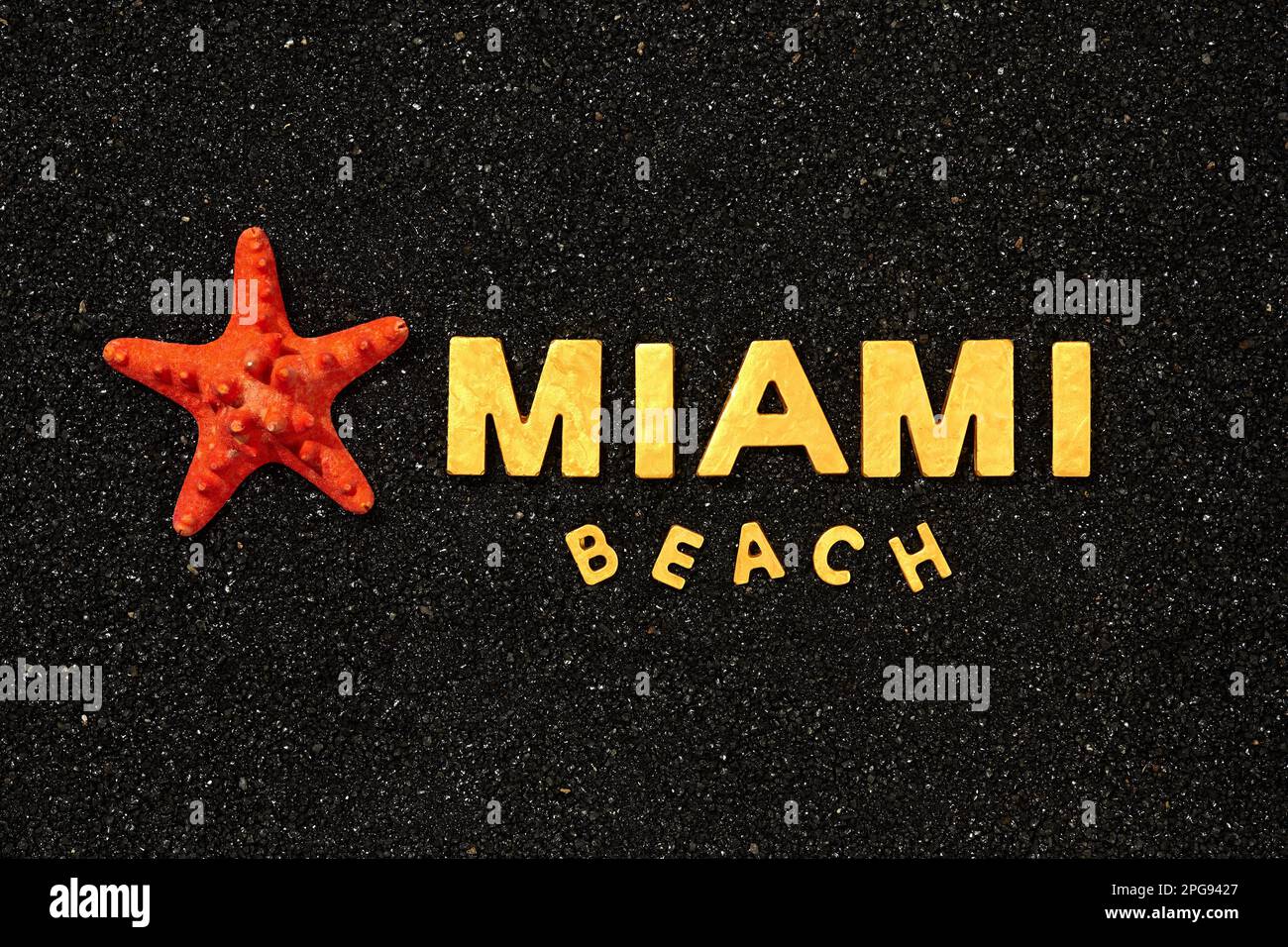 Miami Beach - Golden letters in black sand with red starfish Stock ...