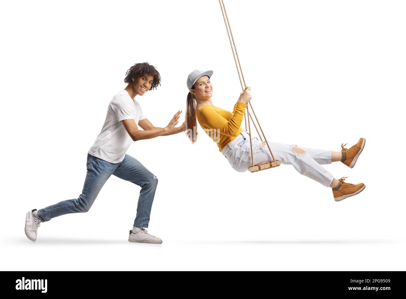 Young african american man pushing a caucasian female on a swing ...