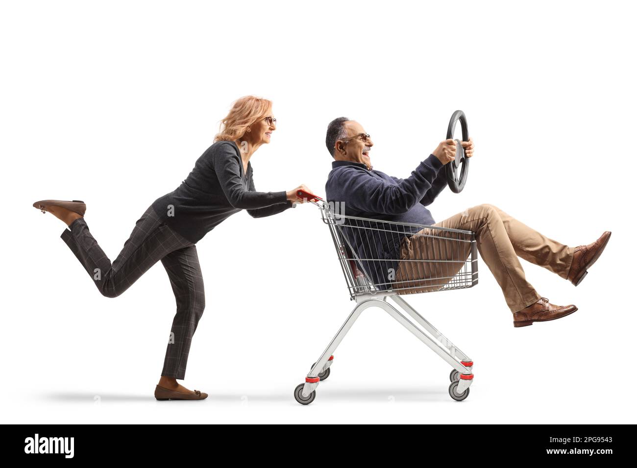 Woman pushing a mature man inside a shopping cart sitting and holding a ...