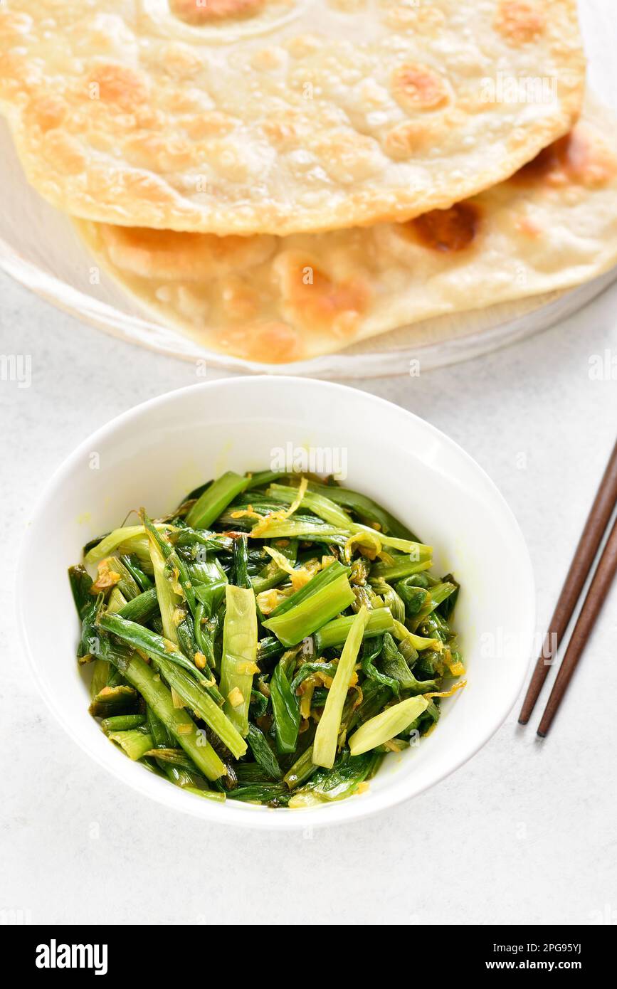 Indian style spring onion stir fry in bowl over white background Stock ...