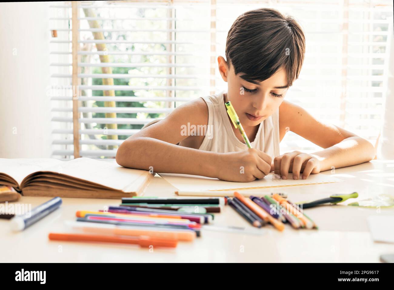 A young child doing his homework at home. the image conveys a positive ...