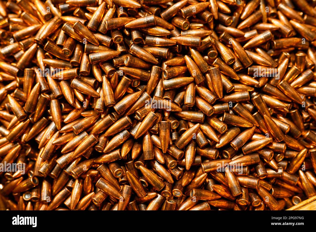 Glowing large caliber bullet heap for riffle as background Stock Photo ...