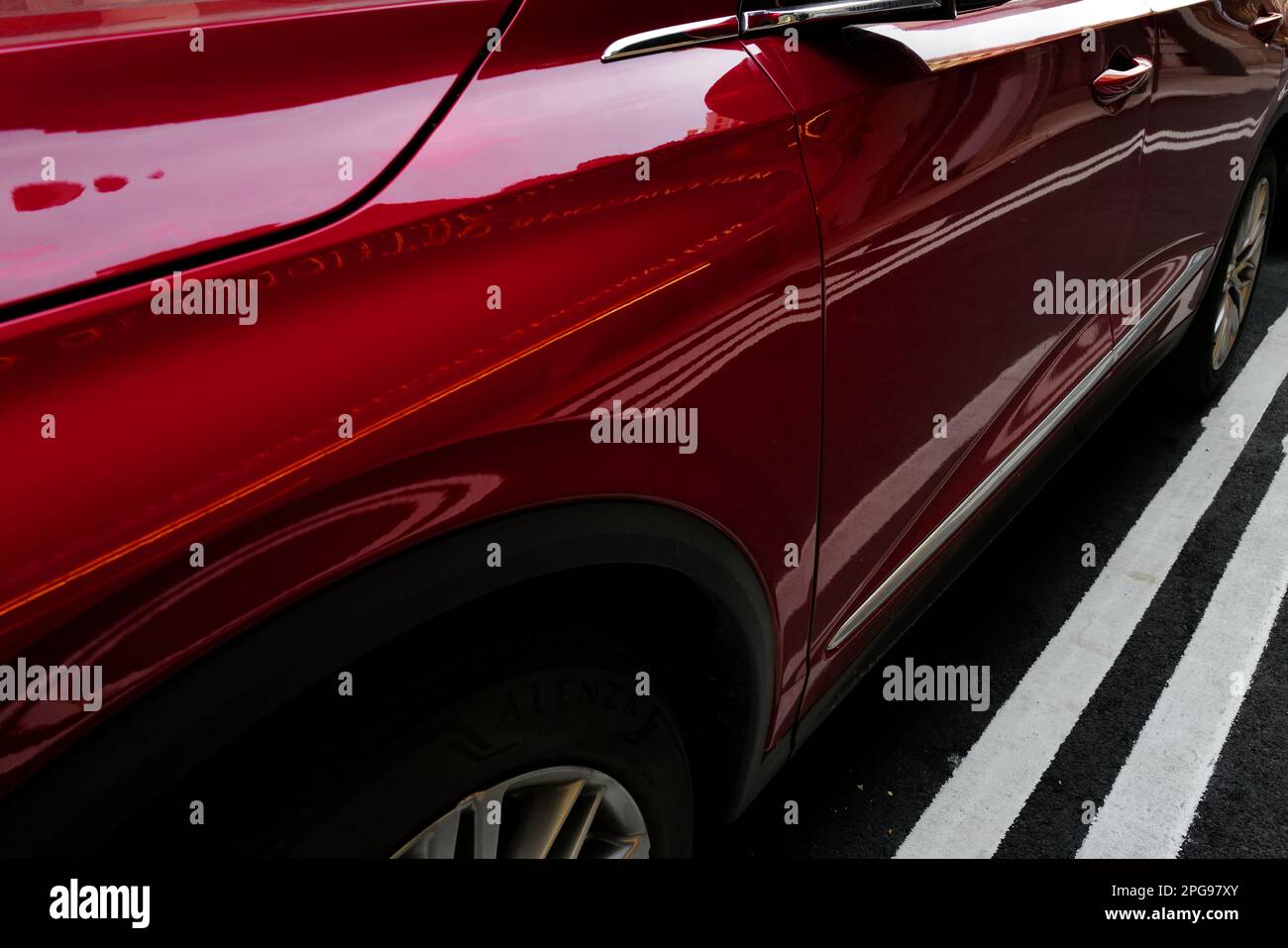 White lines reflected on the side of a red car parked on a New York ...