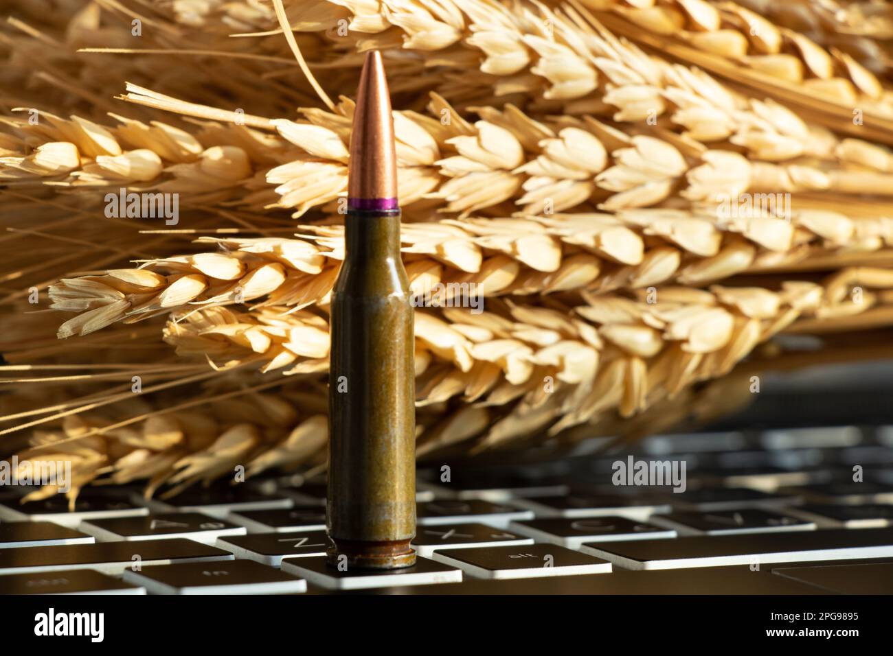 One bullet stands on a black laptop keyboard in the background of ...