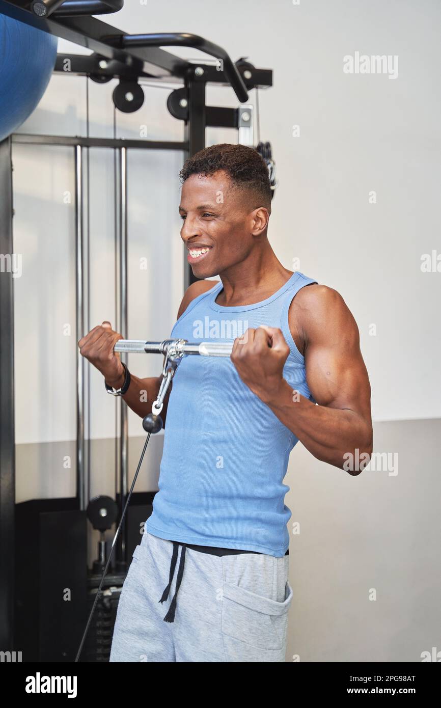 Attractive african man working out with machines at the gym Stock Photo ...