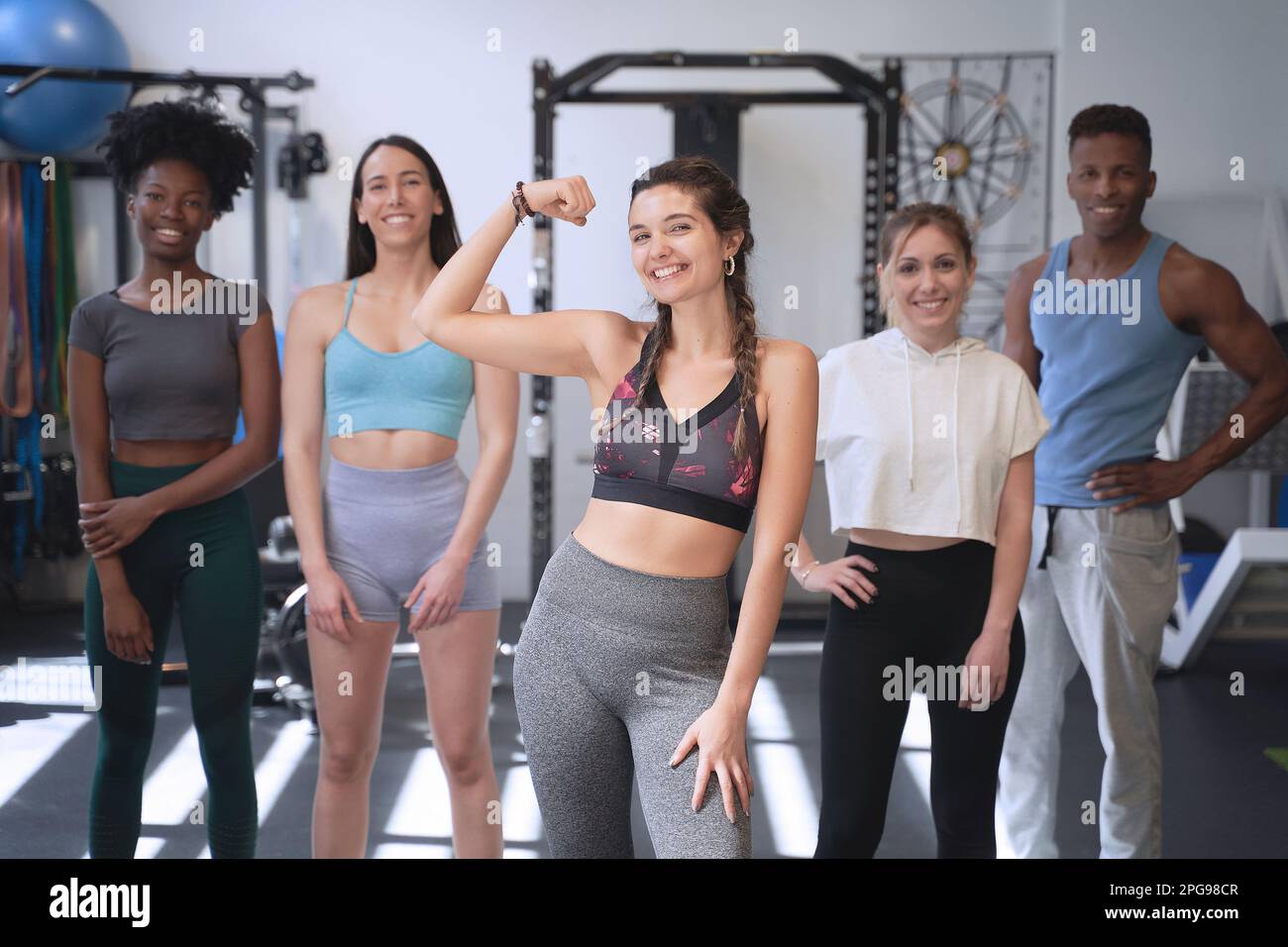 Multi-ethnic fitness group having fun in front of the camera at the gym ...
