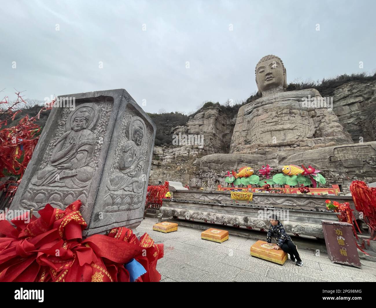 A boy plays at the foot of the Mengshan Giant Buddha in the north peak ...