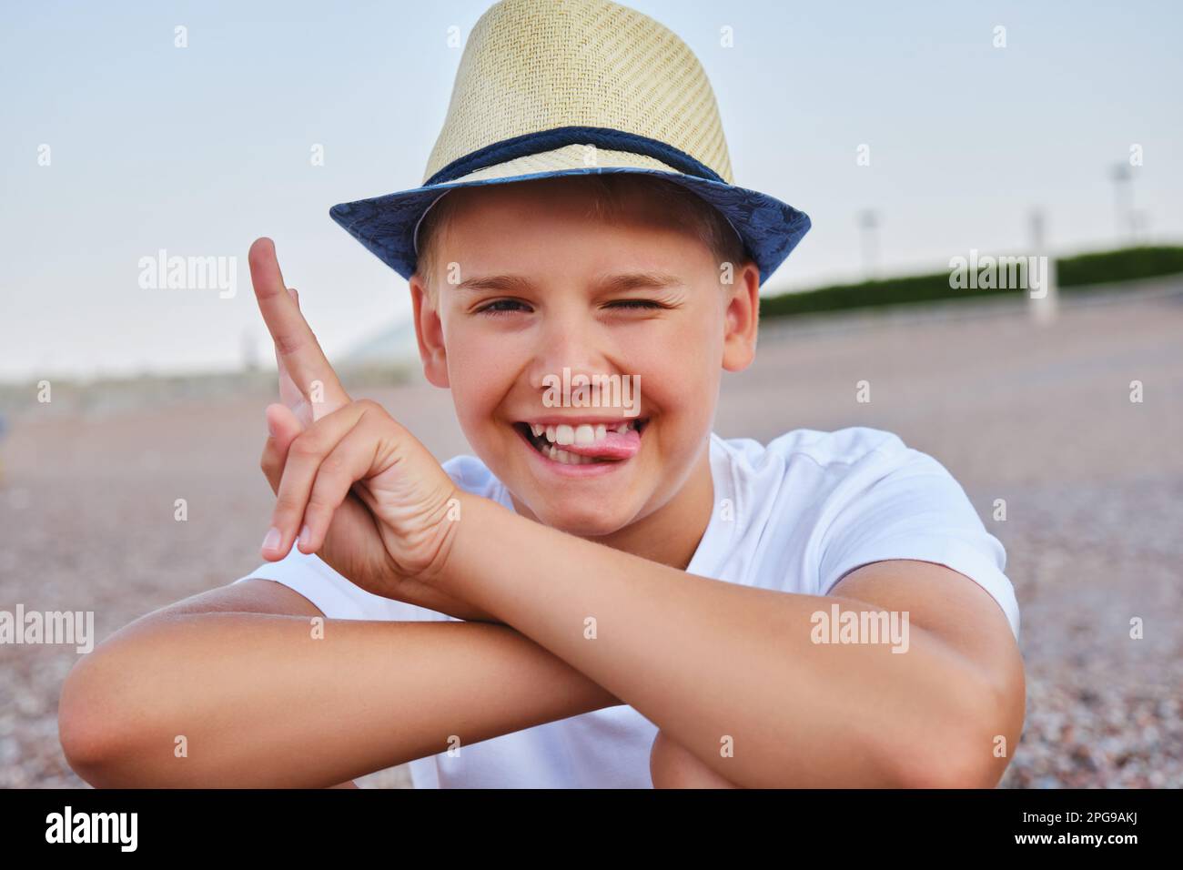 Portrait of a mischievous boy in a stylish hat. A teenage boy makes ...