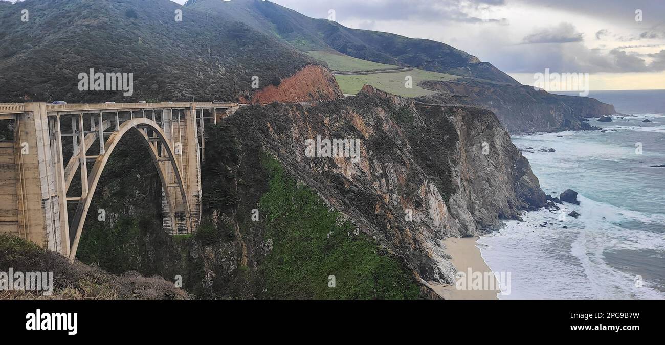 Panoramic view of a bridge spanning across a lush green hillside ...