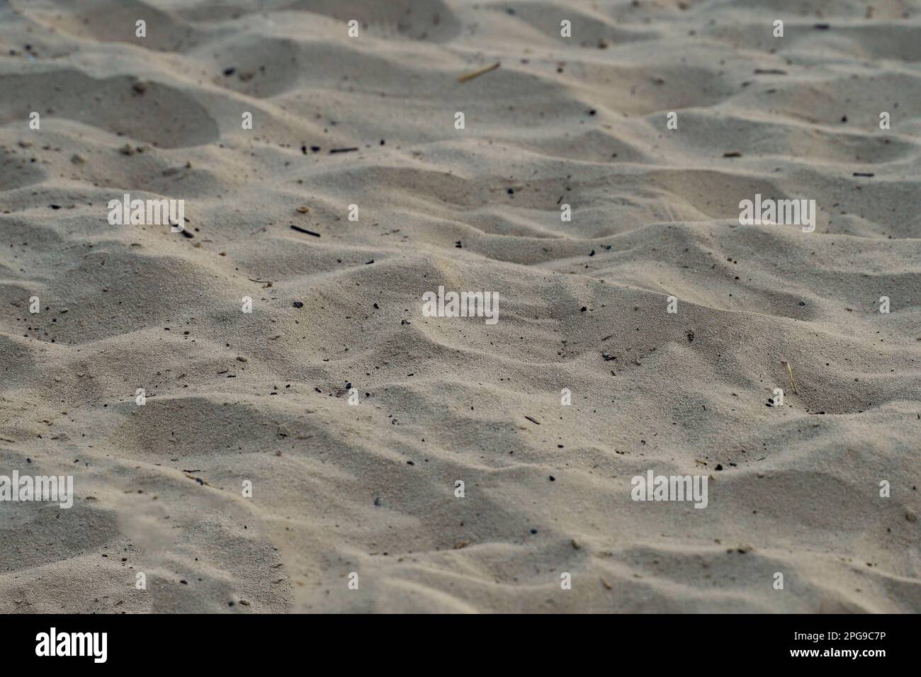 Natural beach sand with particles of garbage. Dirty sand on the beach ...