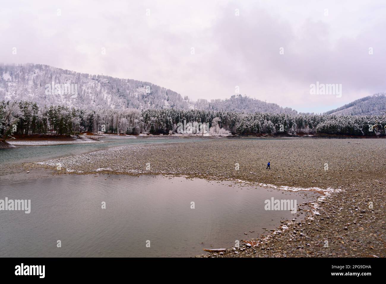 A tourist walks alone on white snow lay down on a picturesque stone ...