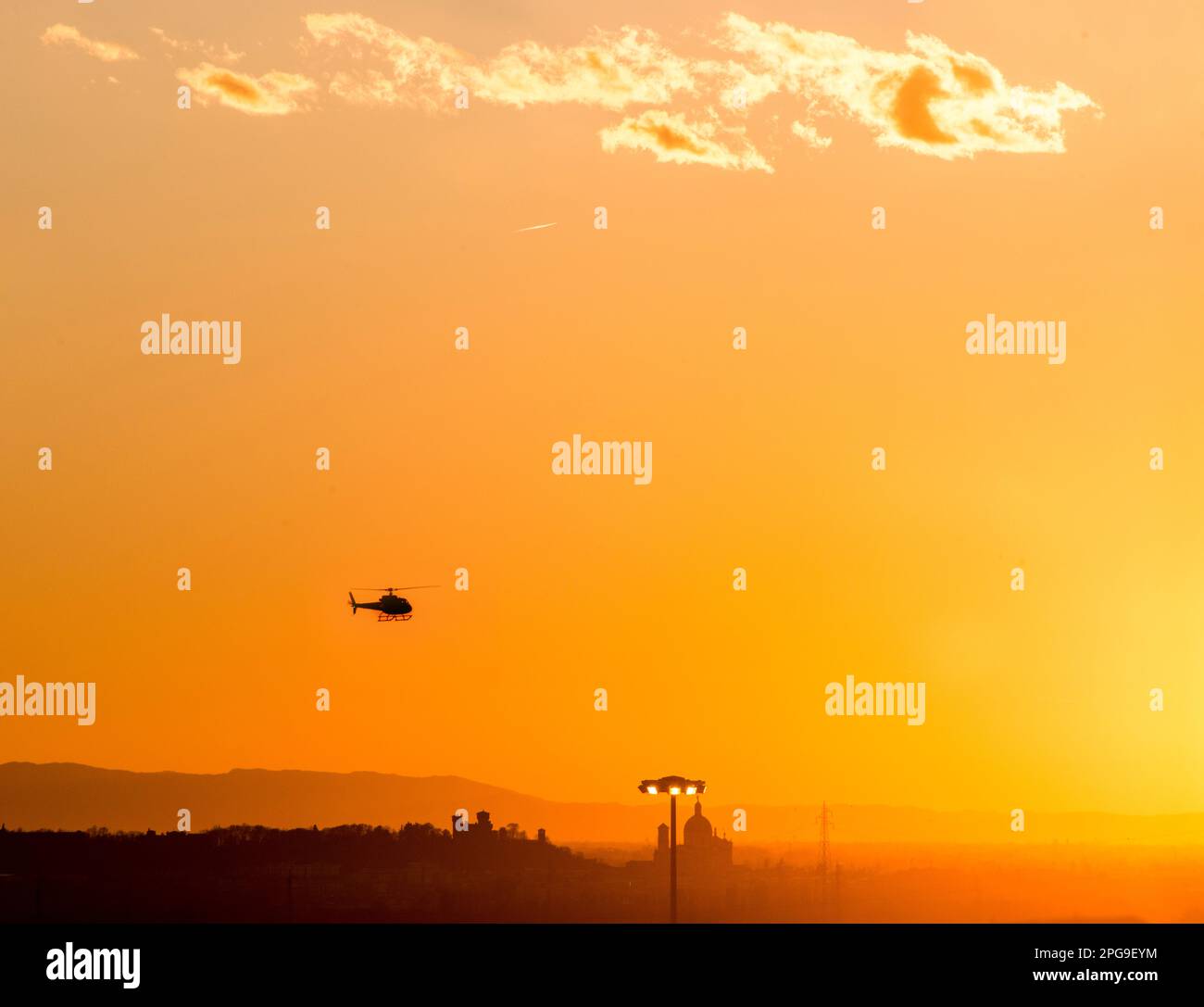 Helicopter is flying in the sunset Stock Photo - Alamy