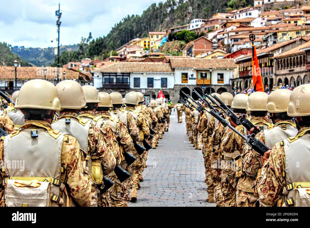 A squad of military personnel in step marching along a paved city ...