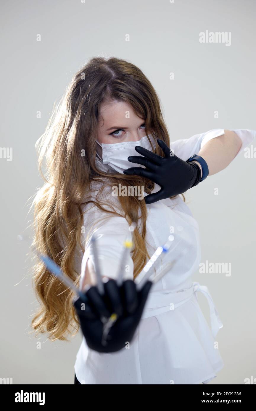 Surgeon holds scalpel dressed in surgical apron and mask light ...