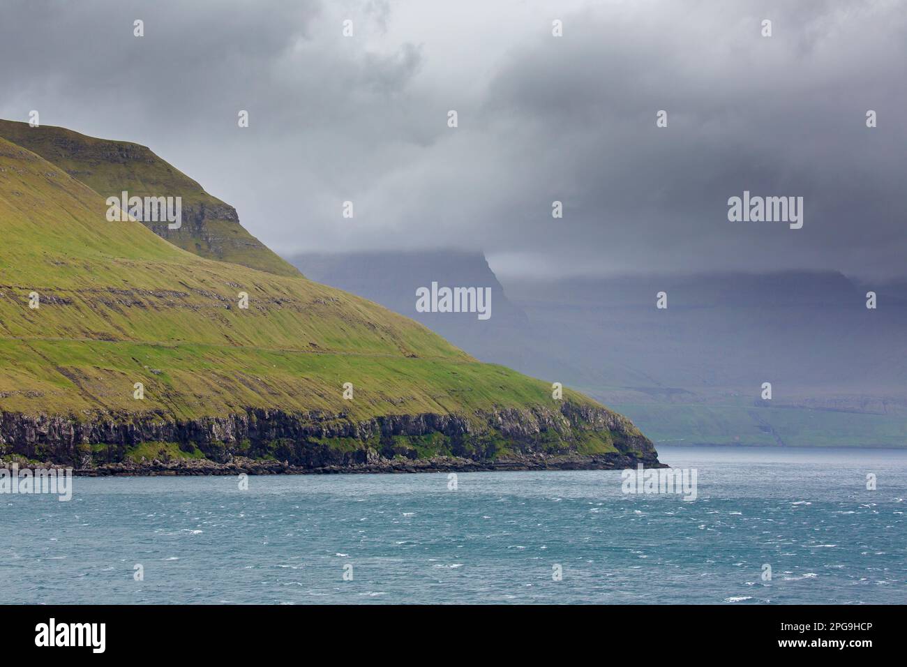Sea cliffs along the rugged coast of Eysturoy / East Island, region and ...