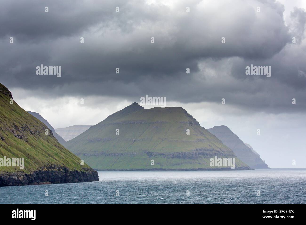 Sea cliffs along the rugged coast of Eysturoy / East Island, region and ...